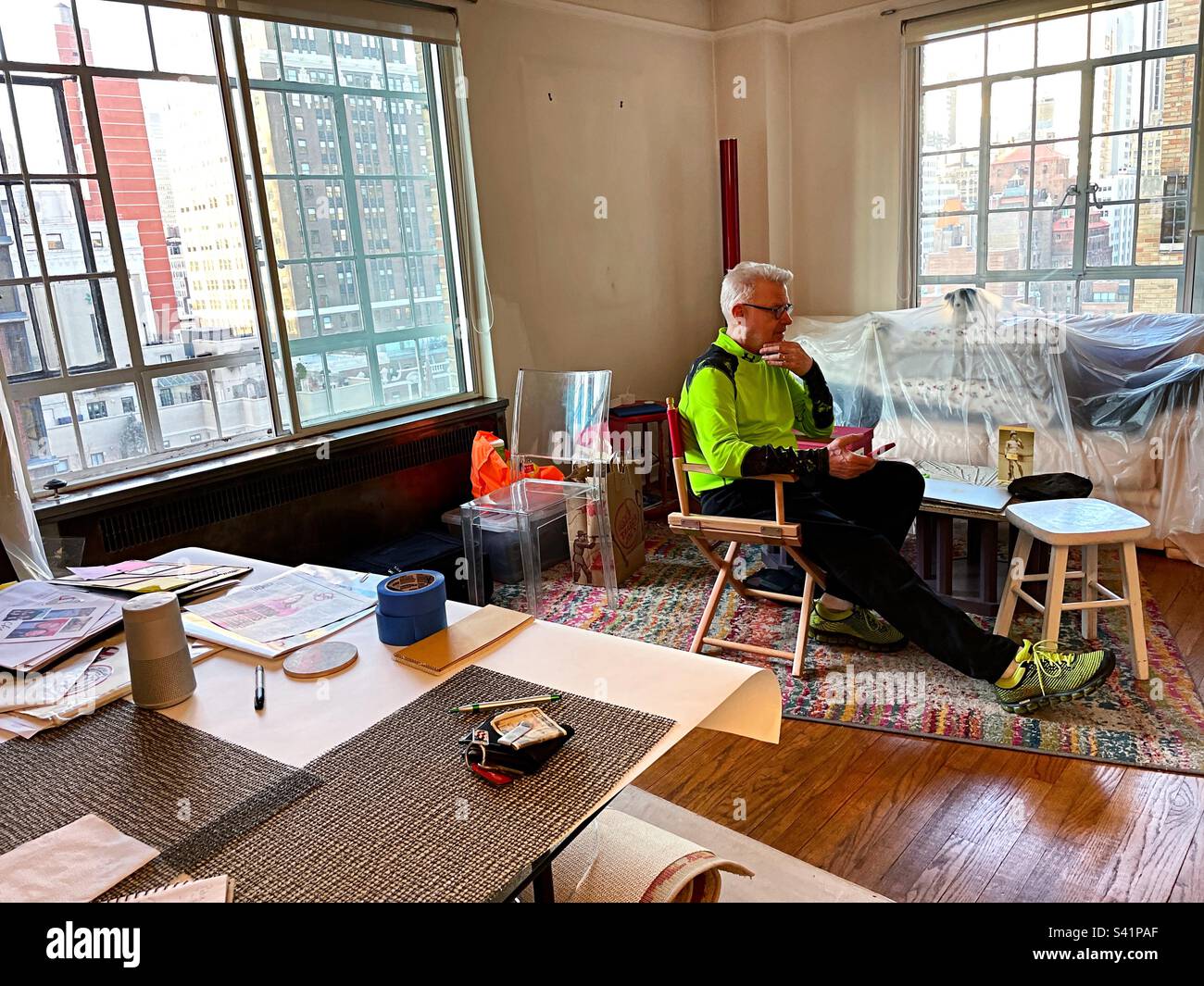 Senior homeowner on his phone in the middle of a home improvement ...