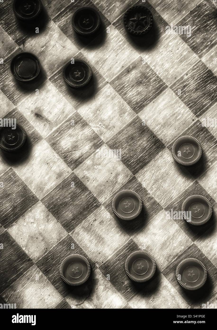Top down nostalgic image of an old weathered checkerboard in sepia tone ...