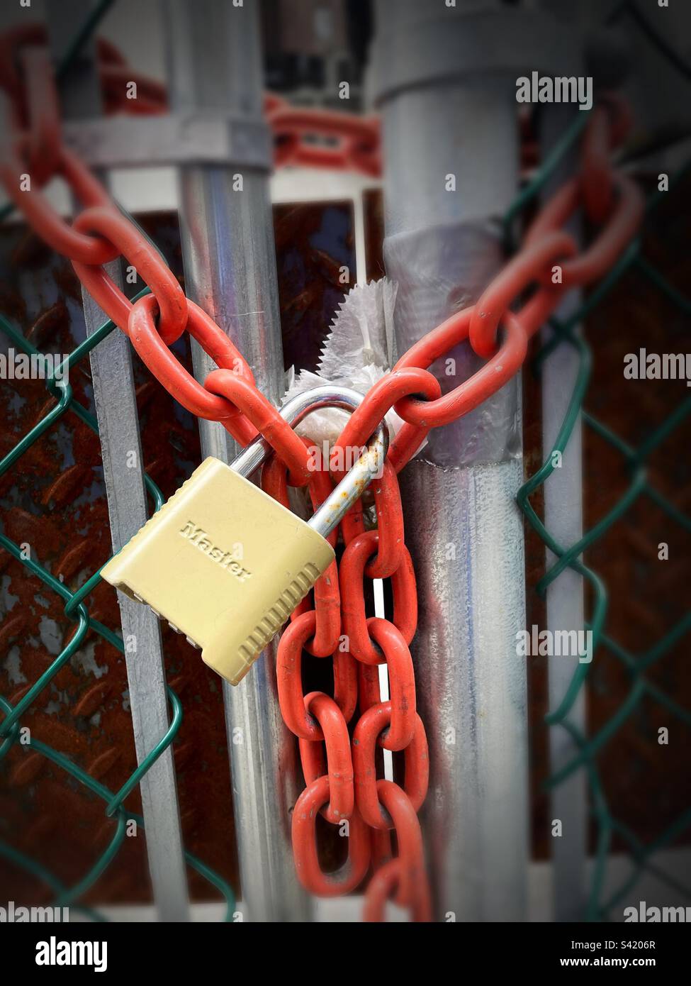 Brass padlock on bright red chain-link fence, 2023, USA Stock Photo - Alamy