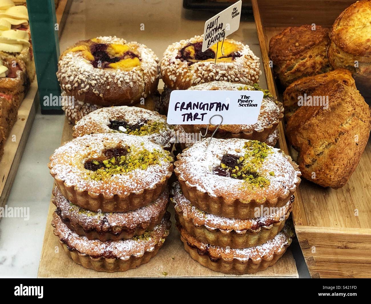Frangipane tart and Fruit Custard brioche in bakery shop window Stock ...
