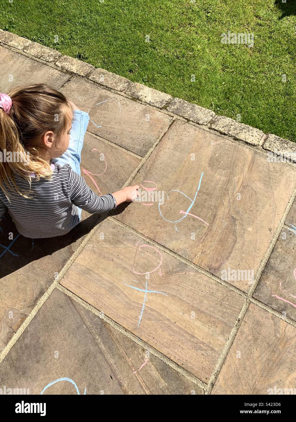 Young girl practicing her letters and numbers in the garden, and using ...