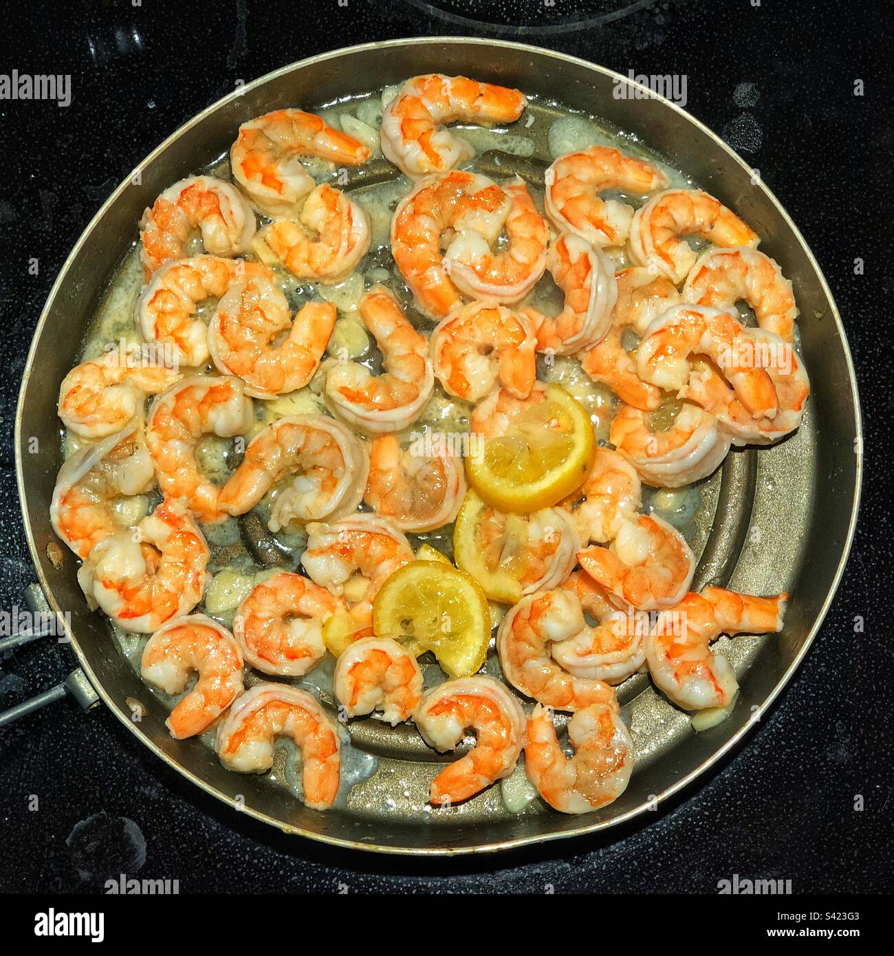 Shrimp in the frying pan with coconut oil, lemon and garlic Stock Photo ...