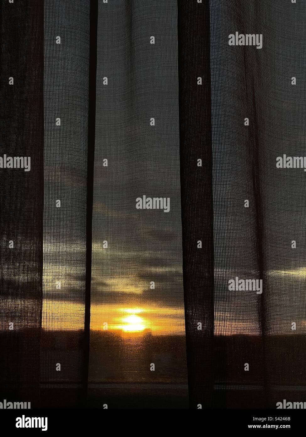 Sunset through the curtain of the window Stock Photo - Alamy