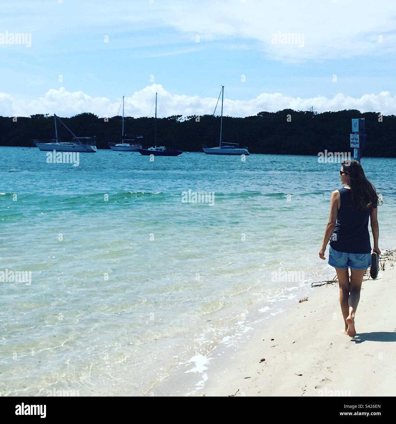 Woman walking on beach Stock Photo - Alamy