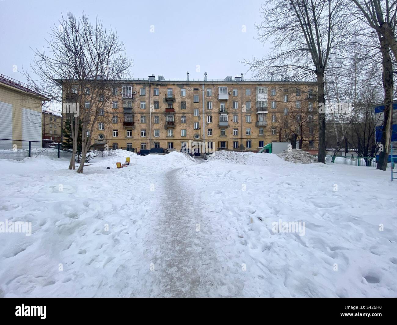 A trail through the snow to an old apartment building in the courtyards ...