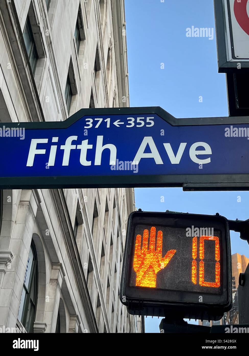 Sign indicating 5th Avenue and traffic lights for pedestrians in New ...