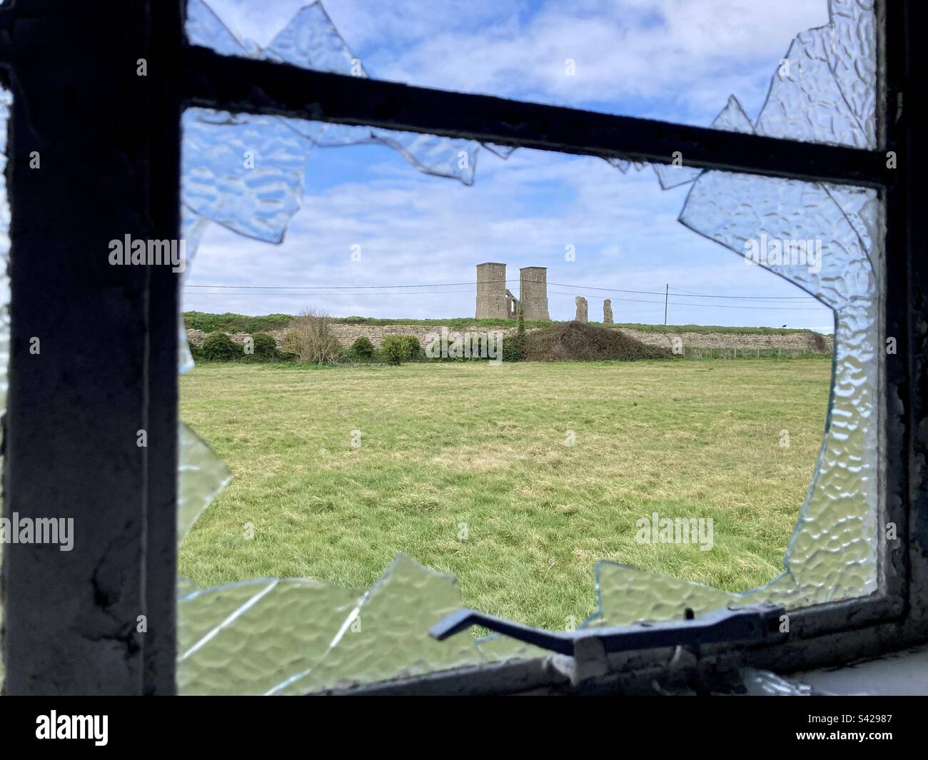 Reculver towers viewed through a smashed window Stock Photo - Alamy