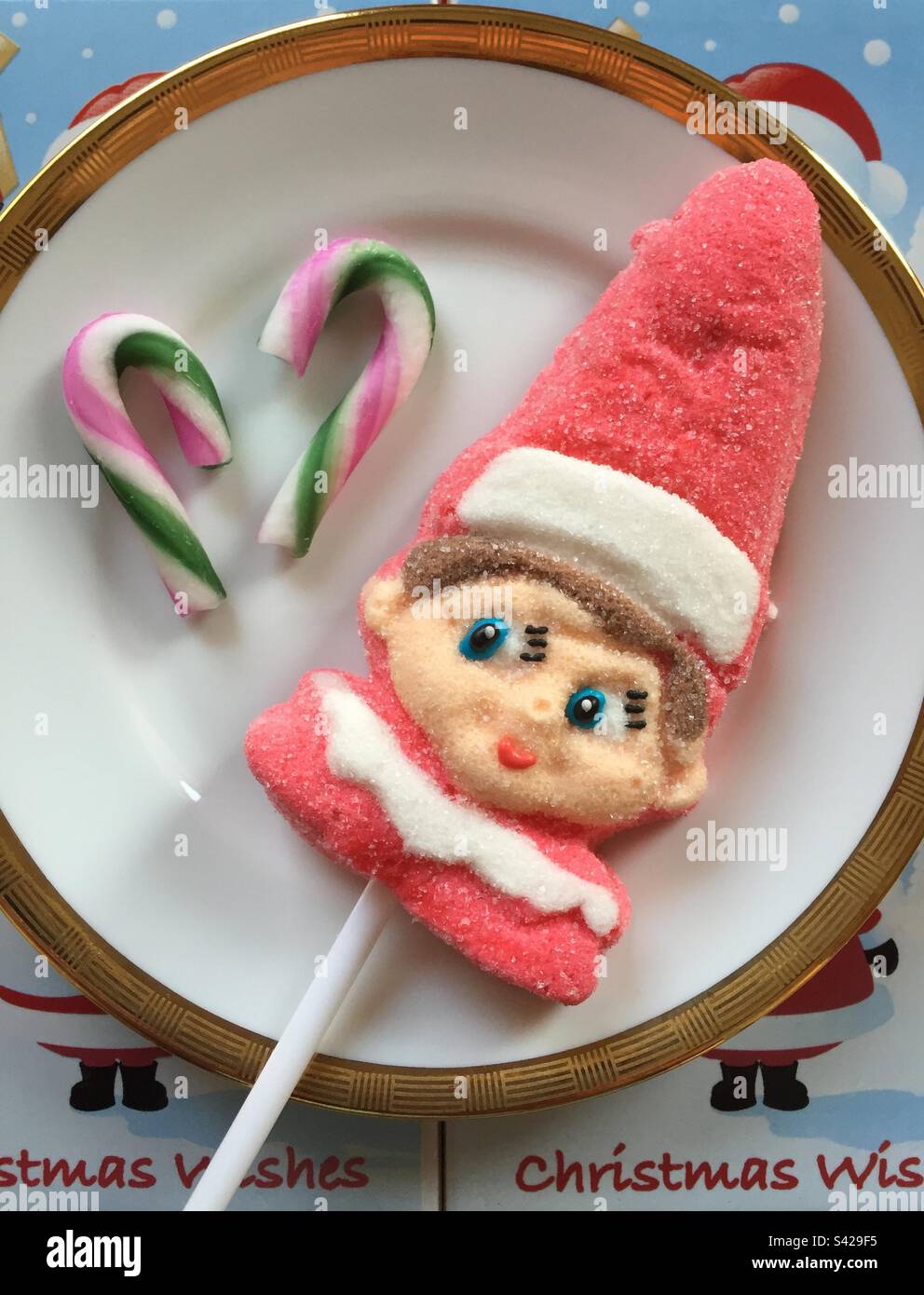 Christmas Elf lollipop, appearing to look at a couple of candy canes on ...