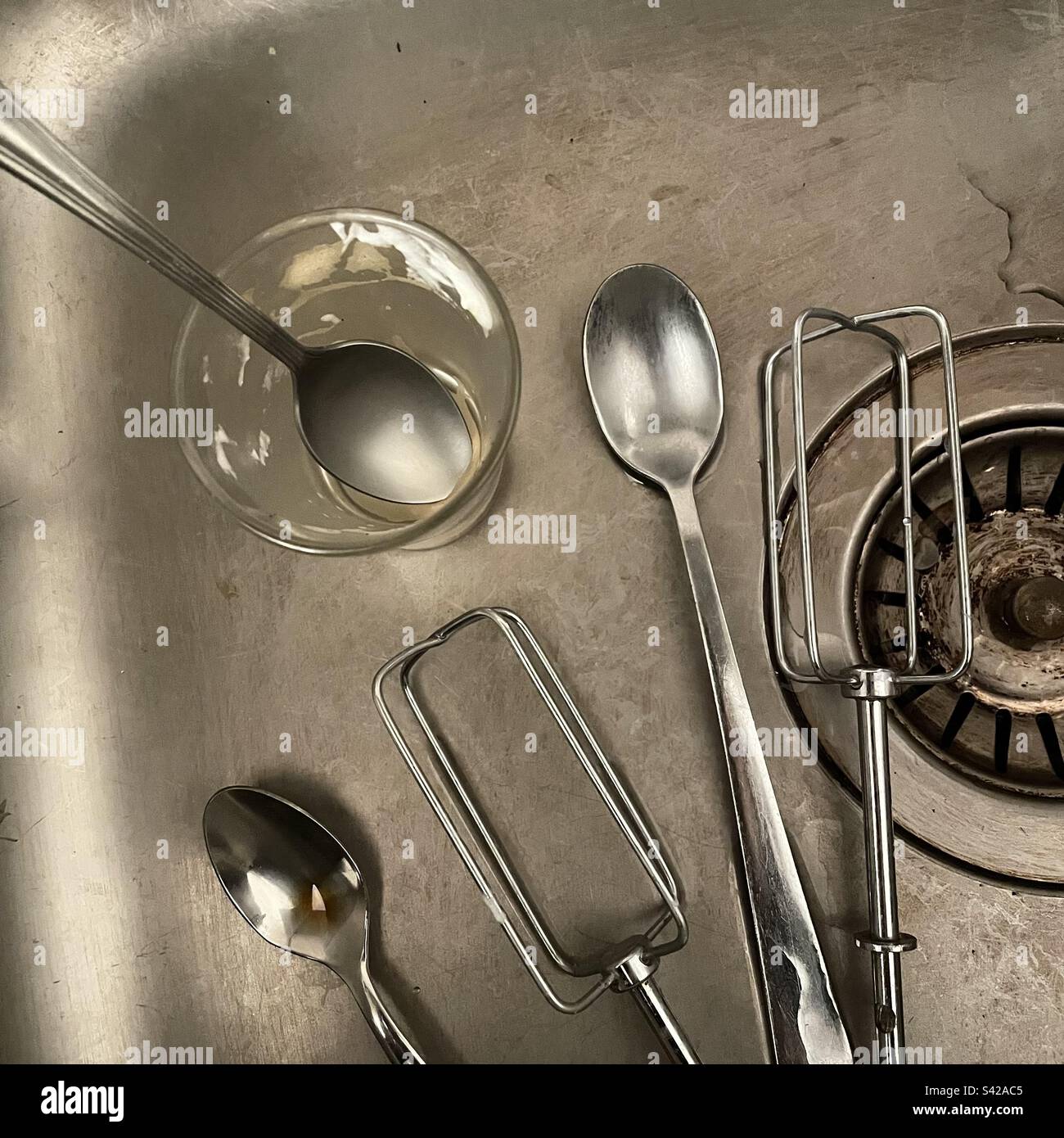 Dirty teaspoons and whisks in steel kitchen sink to be washed and put ...