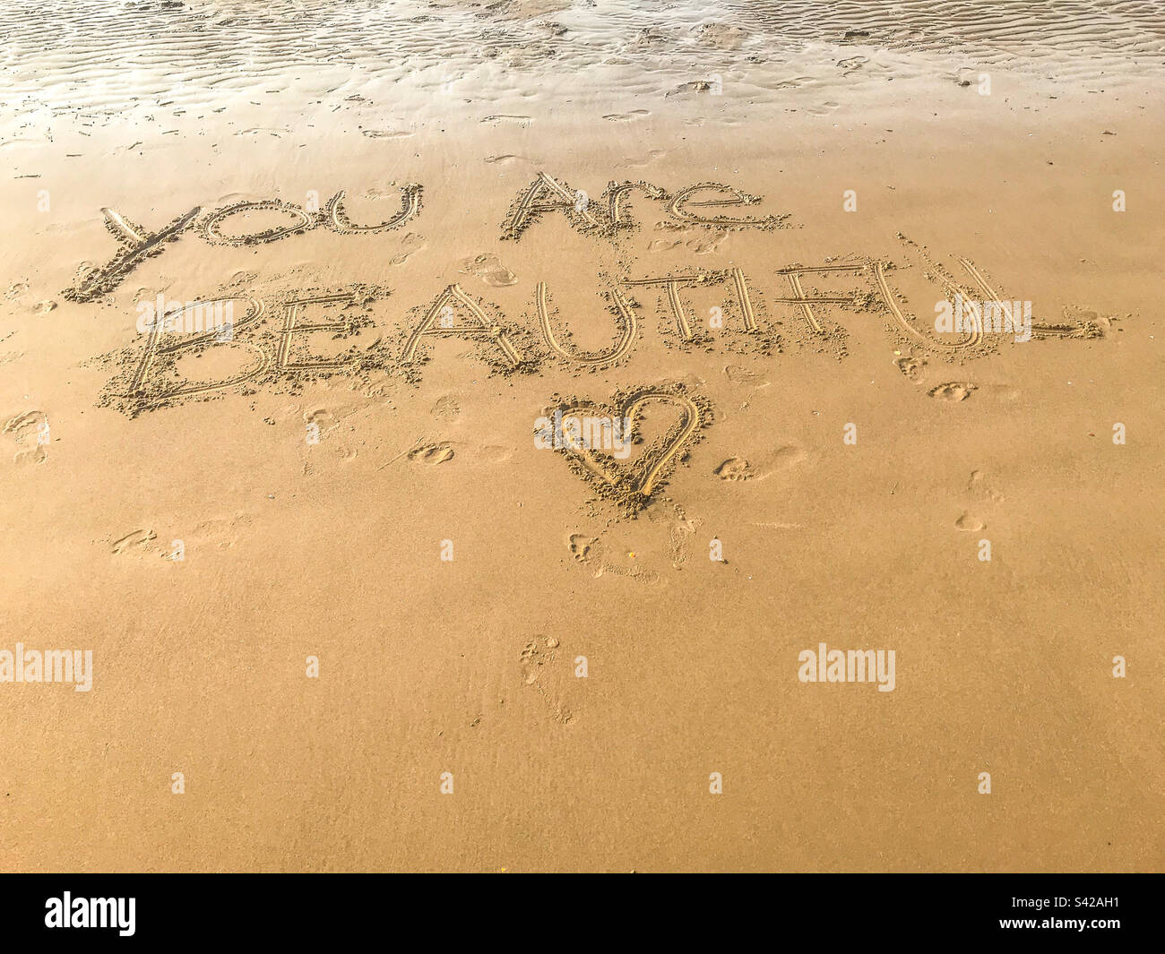 Message written in the sand Stock Photo - Alamy