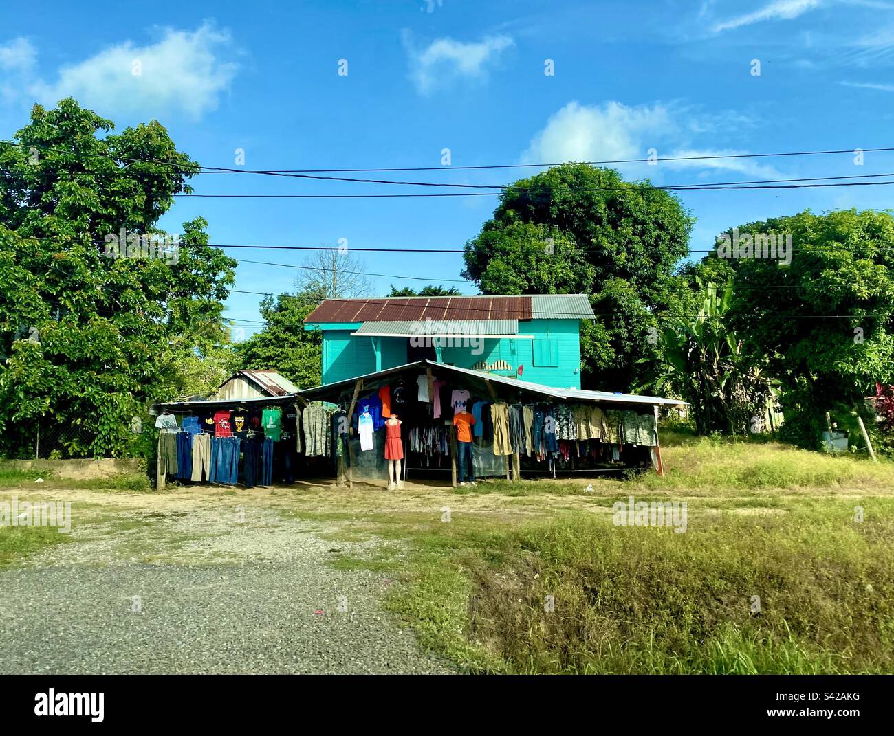 A tourquise house with an unnamed store front outside selling men’s and ...