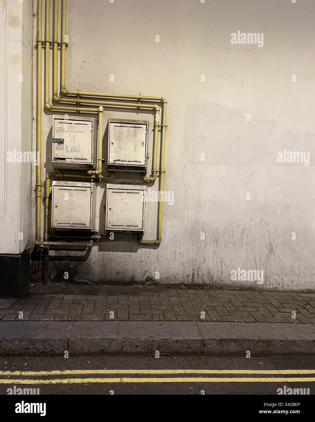 Electric boxes on wall surrounded by yellow lines Stock Photo - Alamy