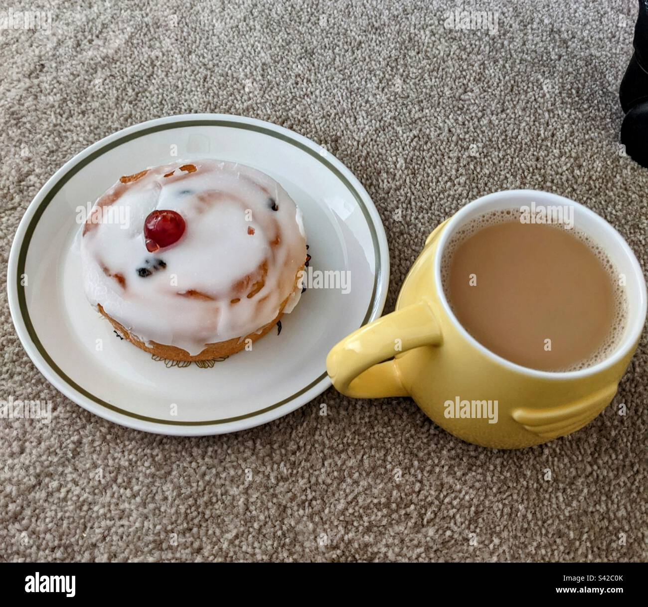 Cake and coffee breakfast time iced with cherry bun Stock Photo - Alamy