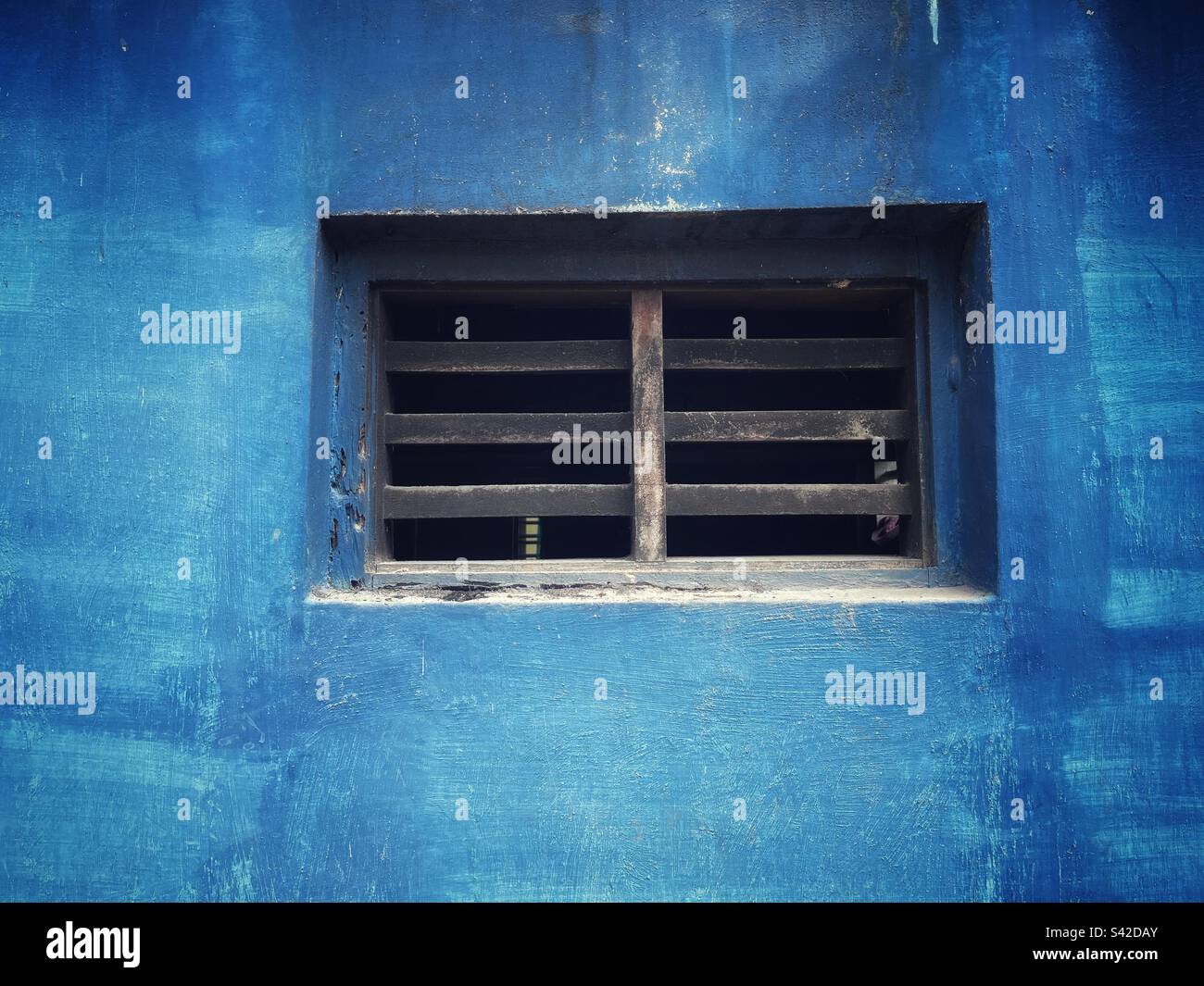 A small window on a blue wall Stock Photo - Alamy