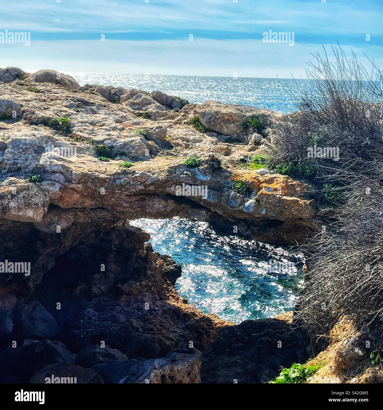 Looking through the rock hole caused by erosion Stock Photo - Alamy