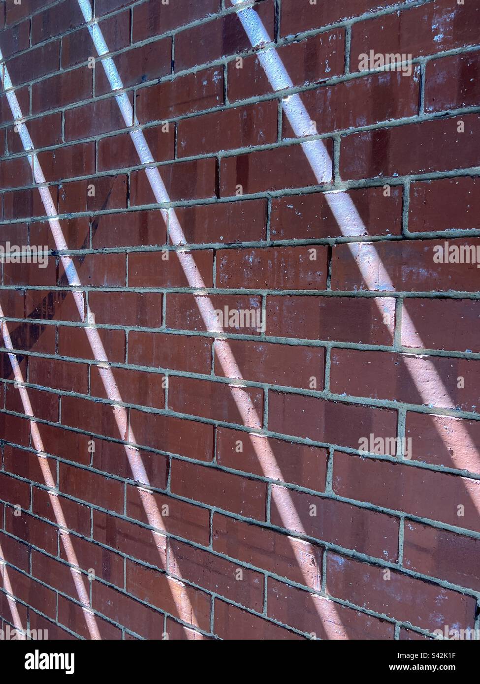 Lines of sunlight streaming onto a brick wall Stock Photo - Alamy