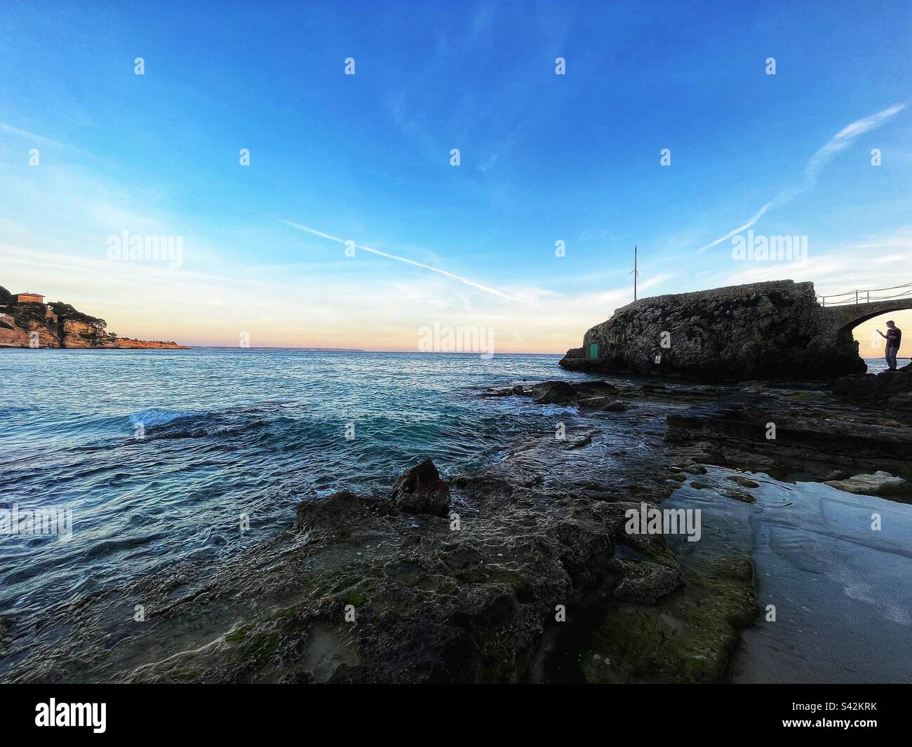 Playa de Cala Mayor, rock and bridge with person under the bridge at ...