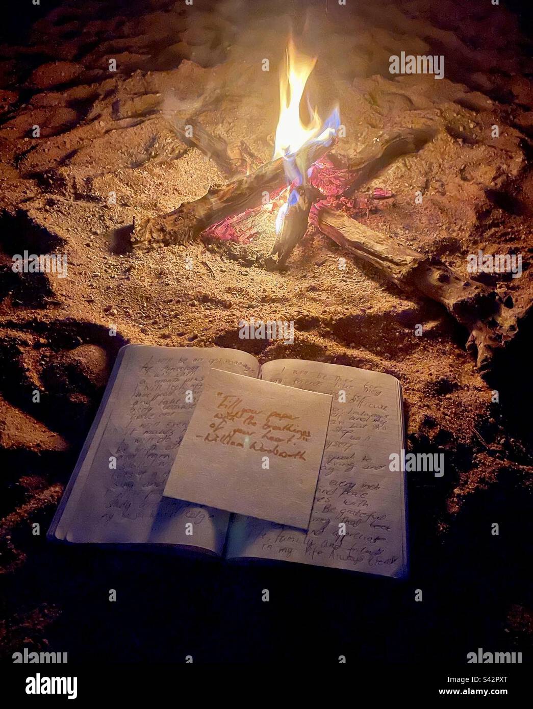 Reading by the fire, photographed on a walking safari in South Africa ...