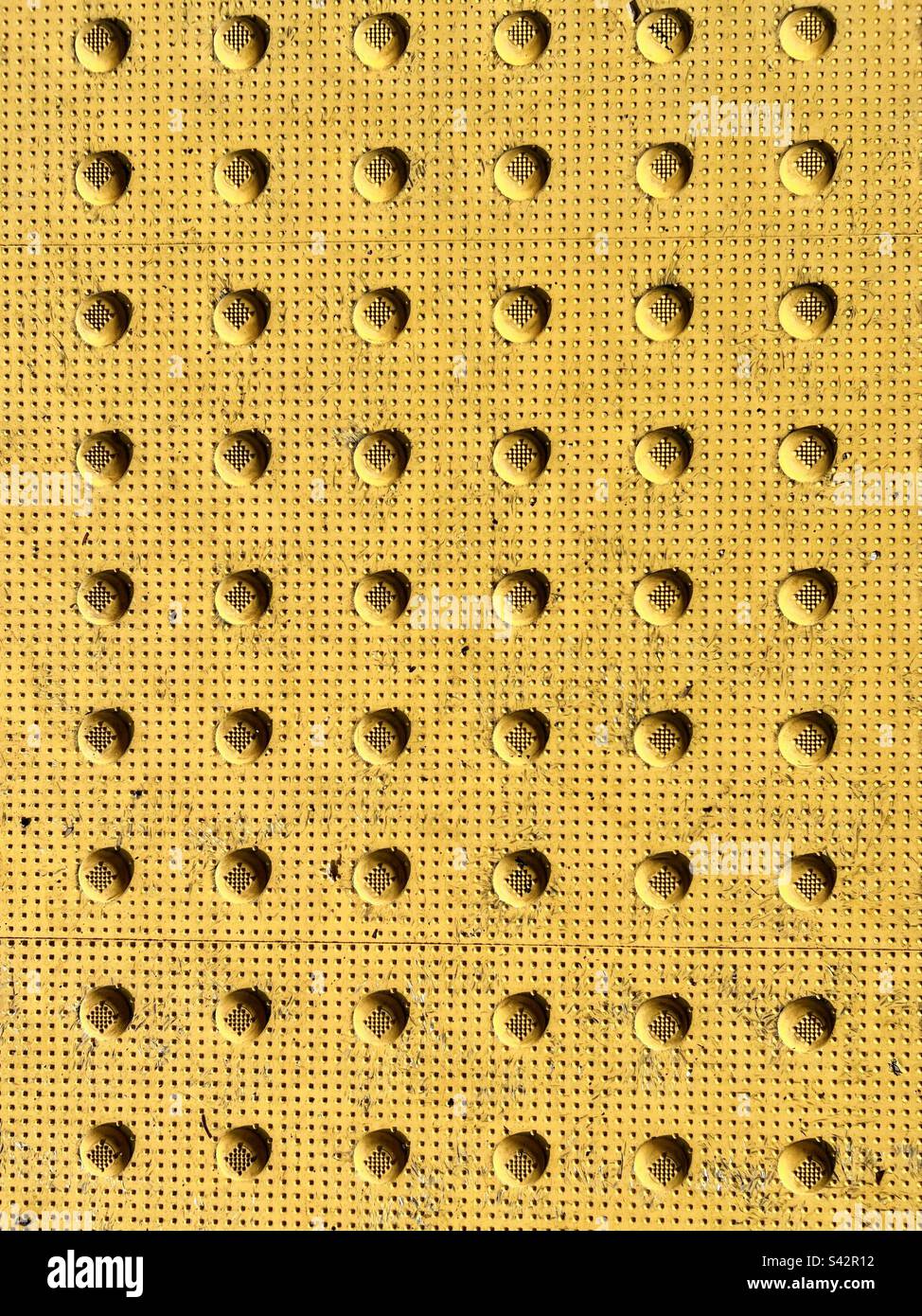 Yellow bumpy patterns where the sidewalk meets the road. These are ...