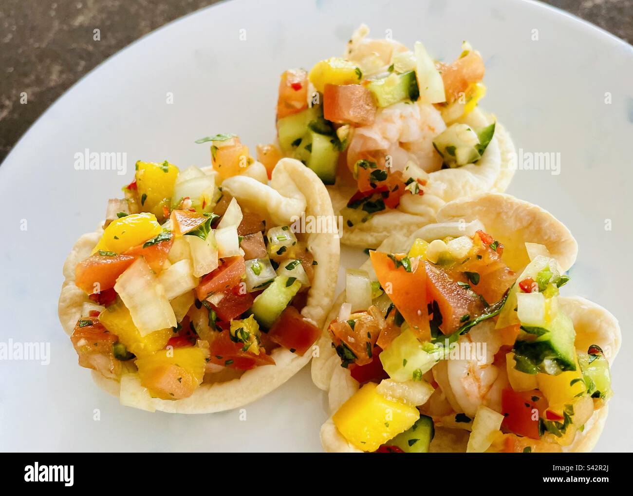 Healthy eating. Three tartlets filled with baby shrimp and mango salsa ...
