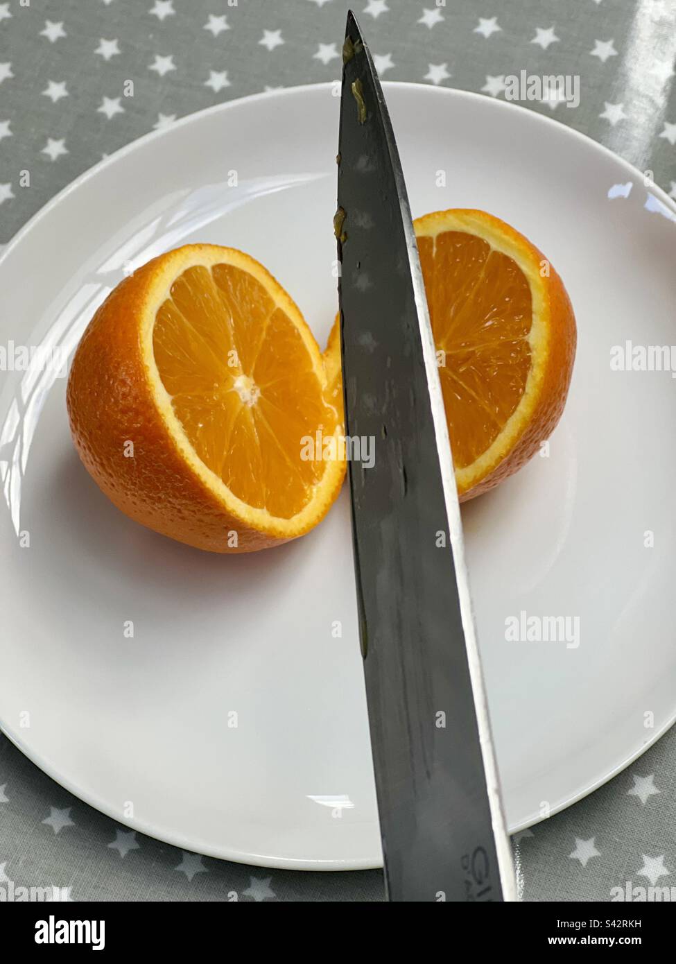 Sharp knife slicing an orange Stock Photo - Alamy