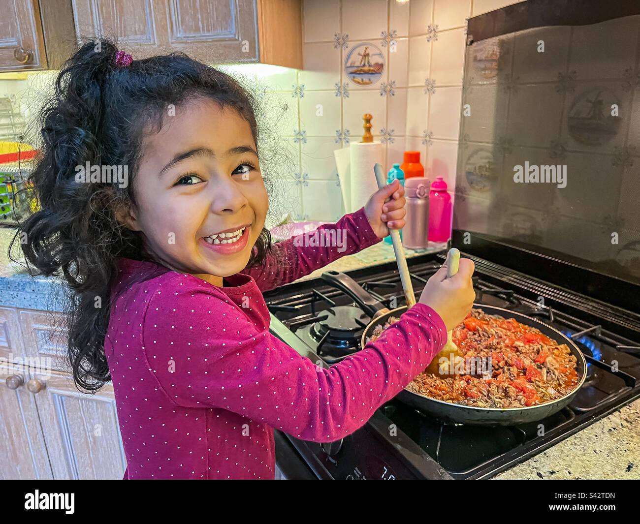 Young girl cooking diner on gas stove Stock Photo - Alamy