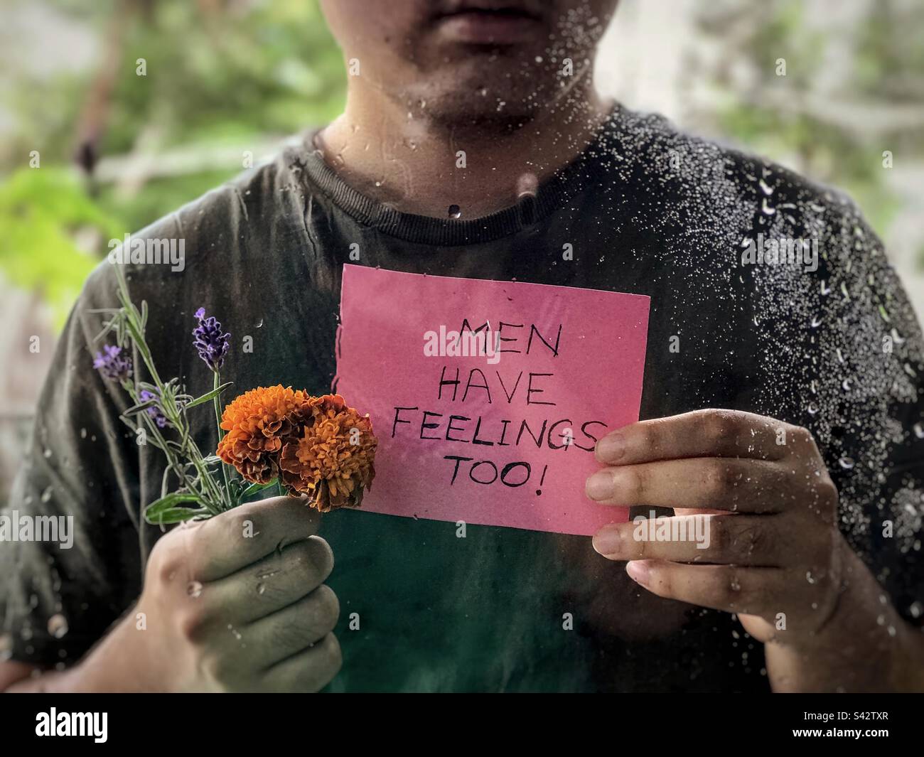 Midsection of man holding pink card with the words: Men have feelings ...