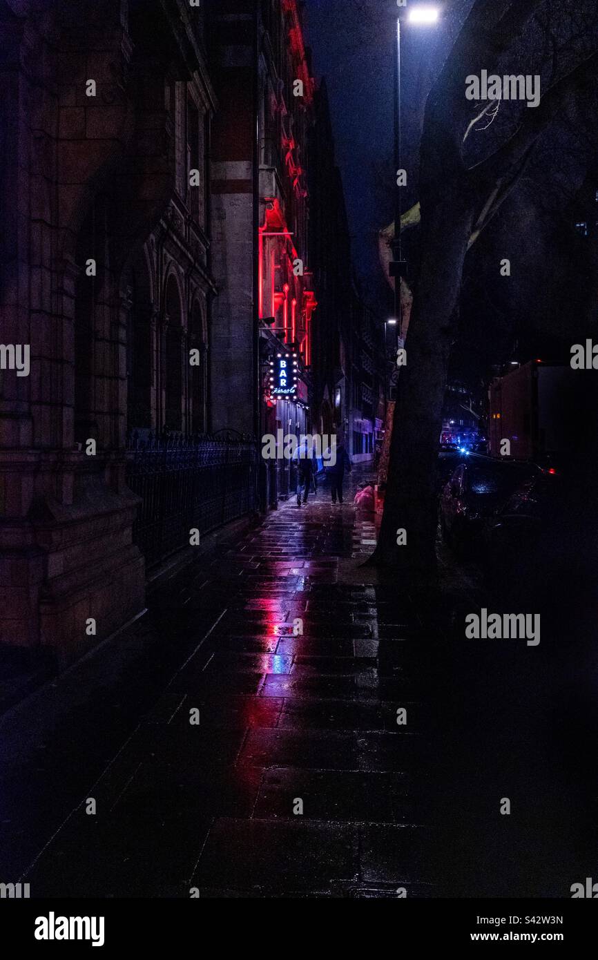 City street at night in the rain with neon bar sign, Shaftesbury Avenue ...