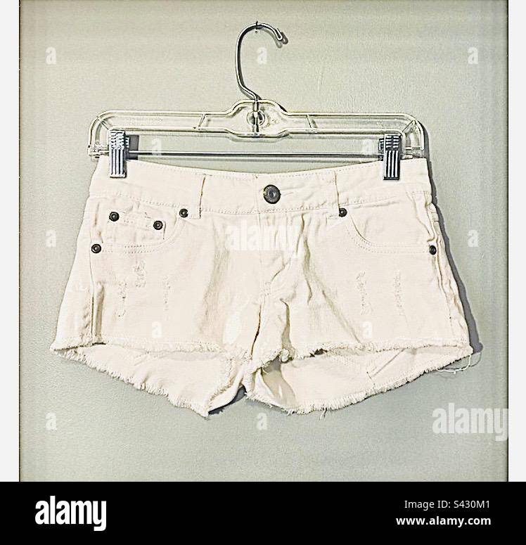 White denim shorts on silver hanger with white background and copy ...