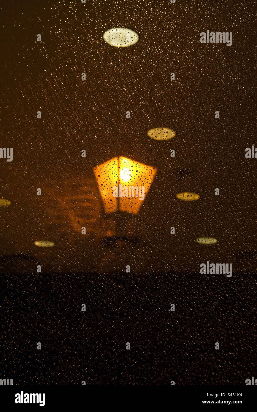 Reflection of lights on a shop window after heavy rain in London ...