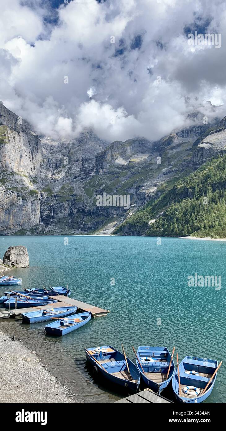 Blue tourist rowing boats moored up on Lake Oeschinen, Switzerland ...