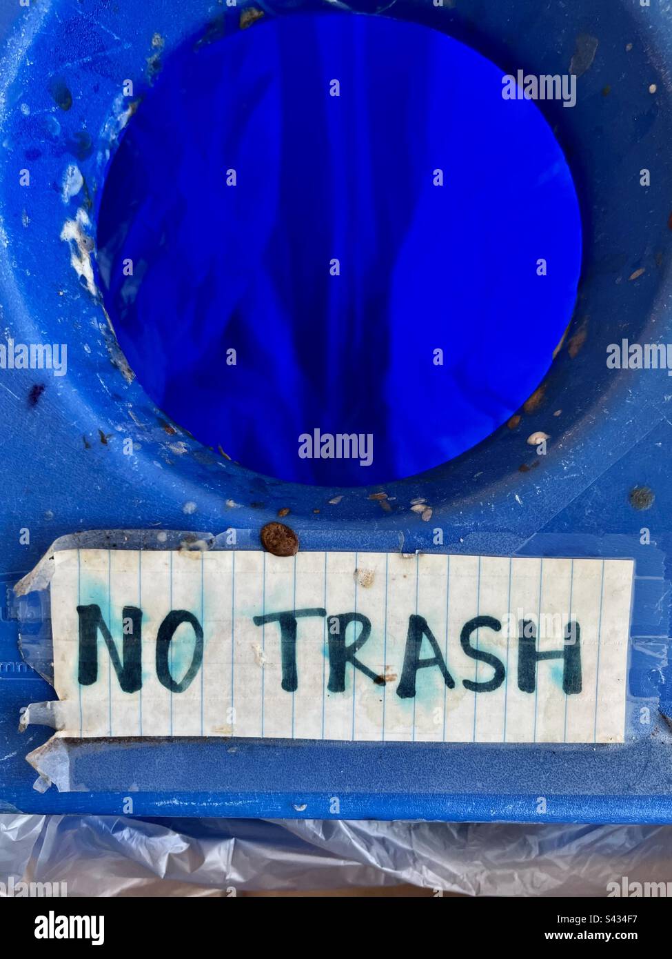 Closeup on circular opening of bright blue recycling container with ...