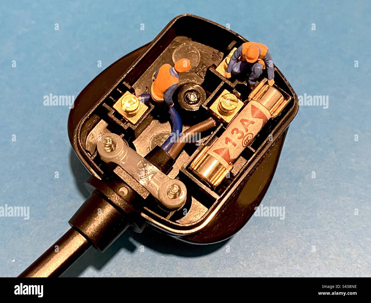 Miniature figure workman in an open electric plug Stock Photo - Alamy