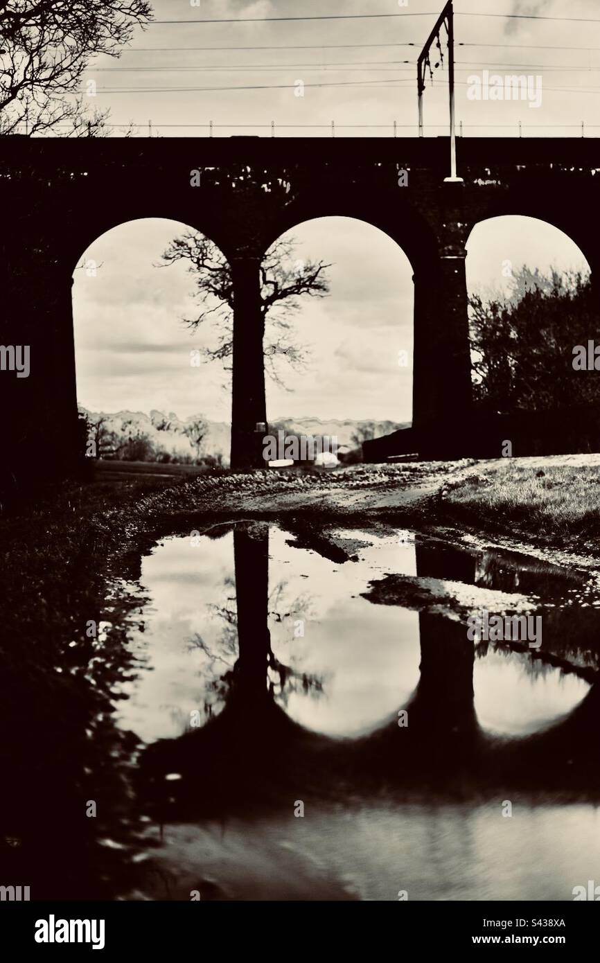 Reflection of a railway bridge in a large puddle of water Stock Photo ...