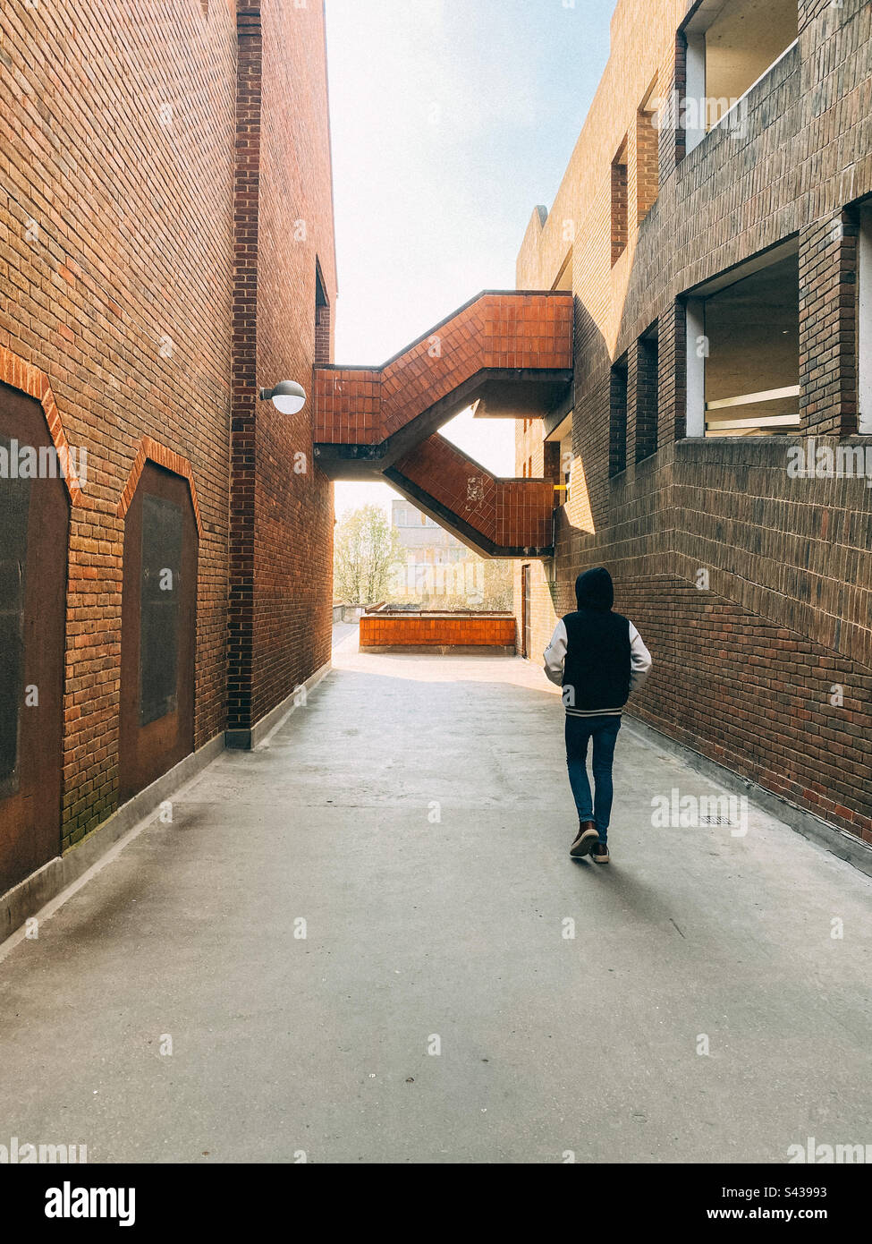 A boy walking along an alleyway Stock Photo - Alamy
