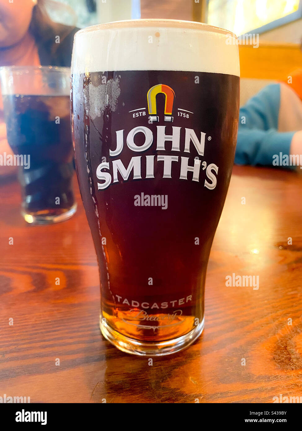 A pint of John Smith’s beer on a wooden table in a pub Stock Photo - Alamy