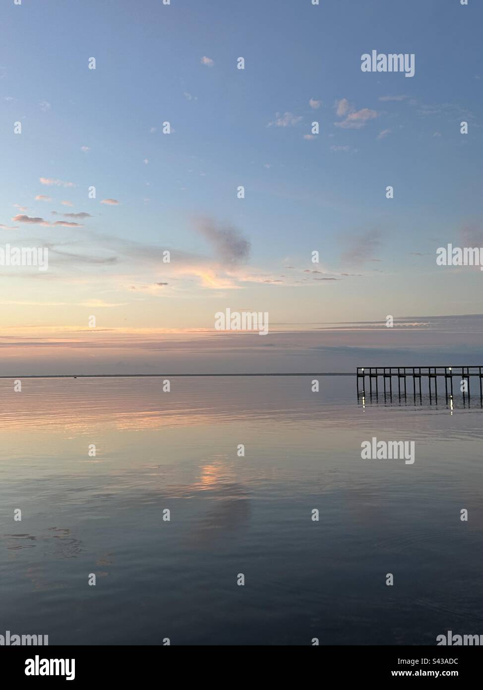 Florida panhandle sunset with pier and reflections onto the ...