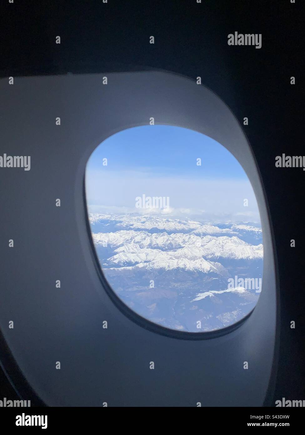View of the Alps from an airplane window mid-flight Stock Photo - Alamy