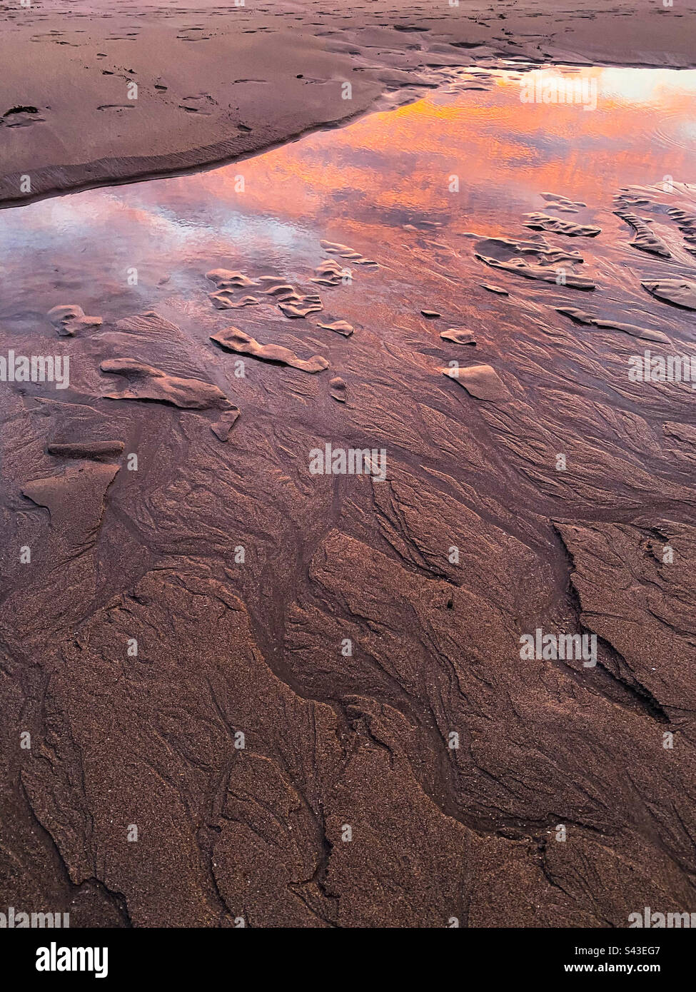 Sunset reflection on the beach Stock Photo - Alamy