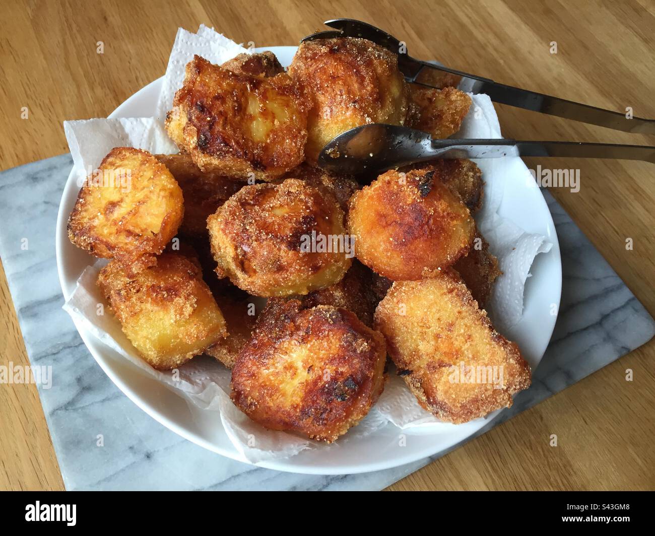 Roast potatoes in a serving dish. Golden brown roast potatoes, crunchy ...
