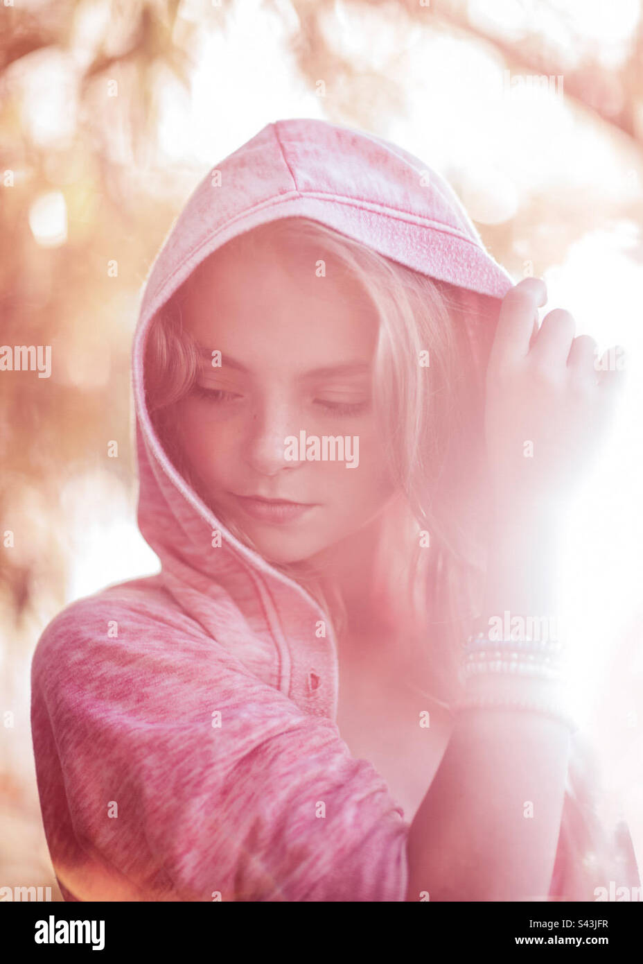Portrait of young girl in a pink hoodie Stock Photo - Alamy