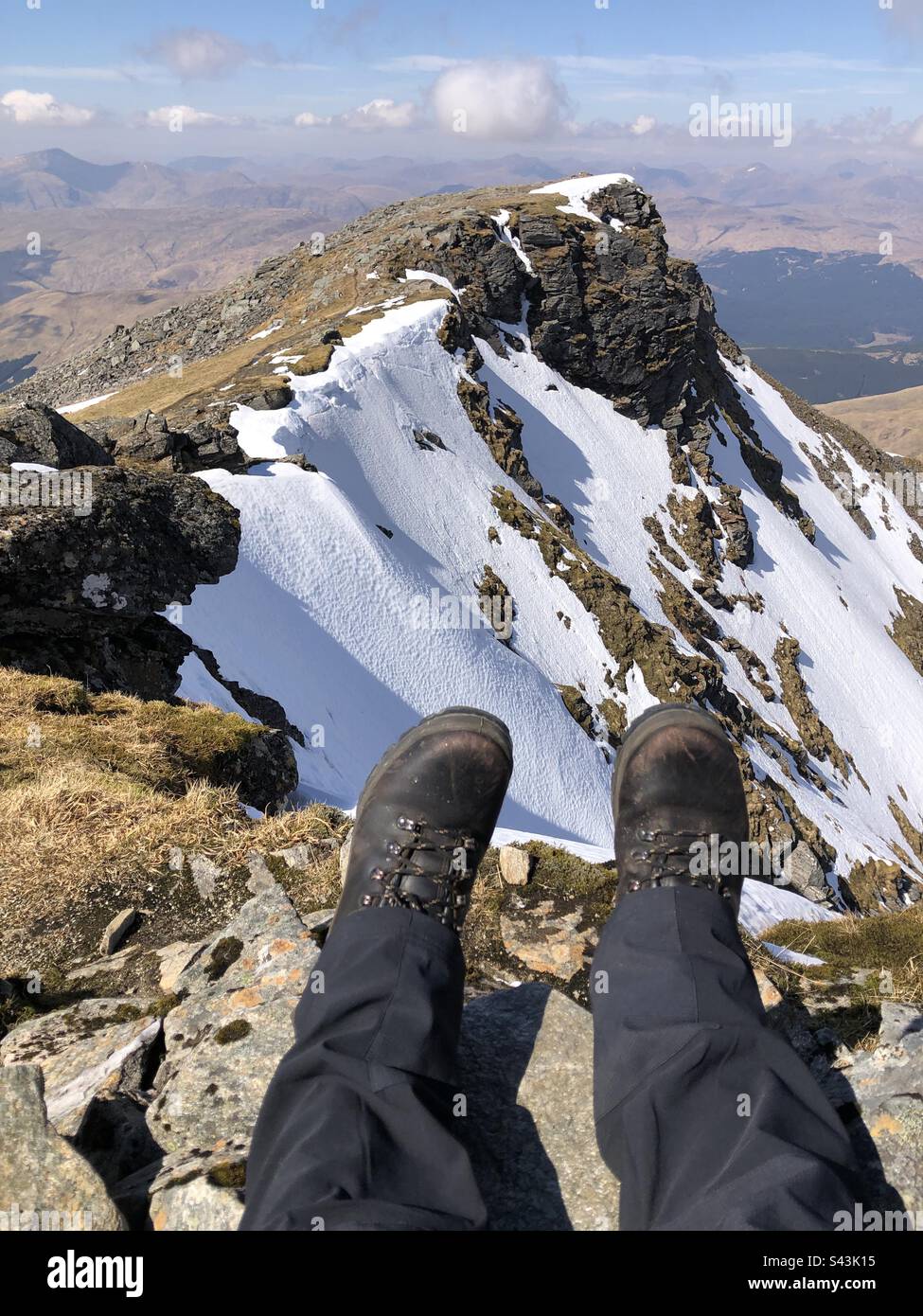 A Walker wearing a pair of leather boots on the summit of Ben Lui, with ...