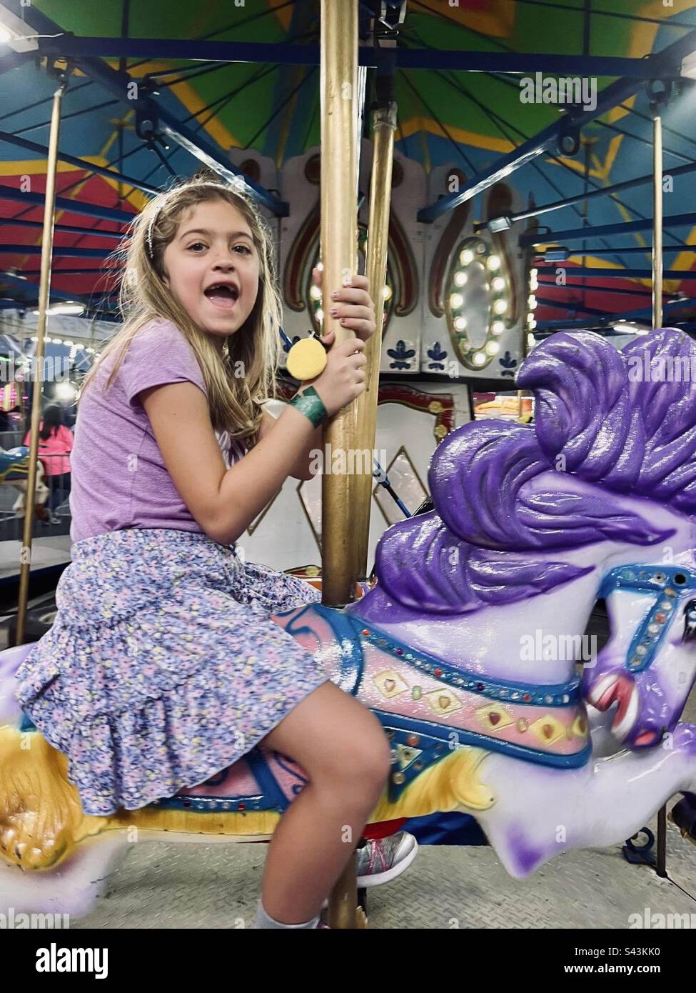 Cute little girl having fun on a merry go round Stock Photo - Alamy