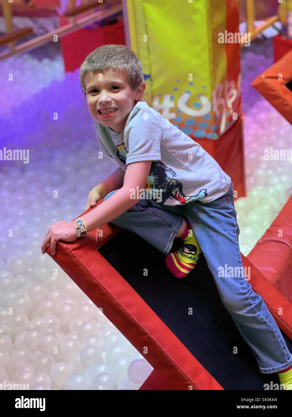 Young boy having fun playing in a ball pit Stock Photo - Alamy
