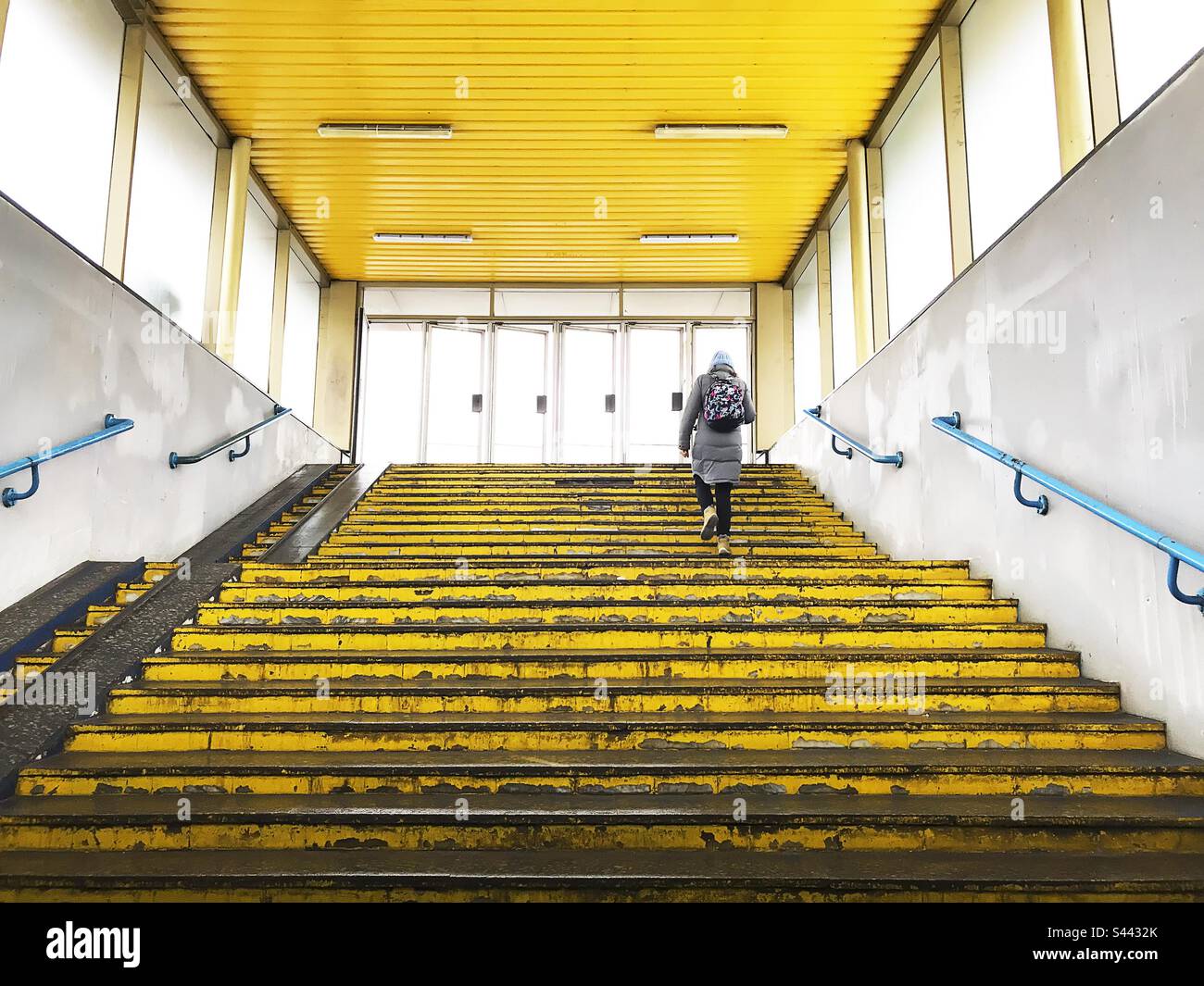 Walking with a backpack by yellow steps Stock Photo - Alamy
