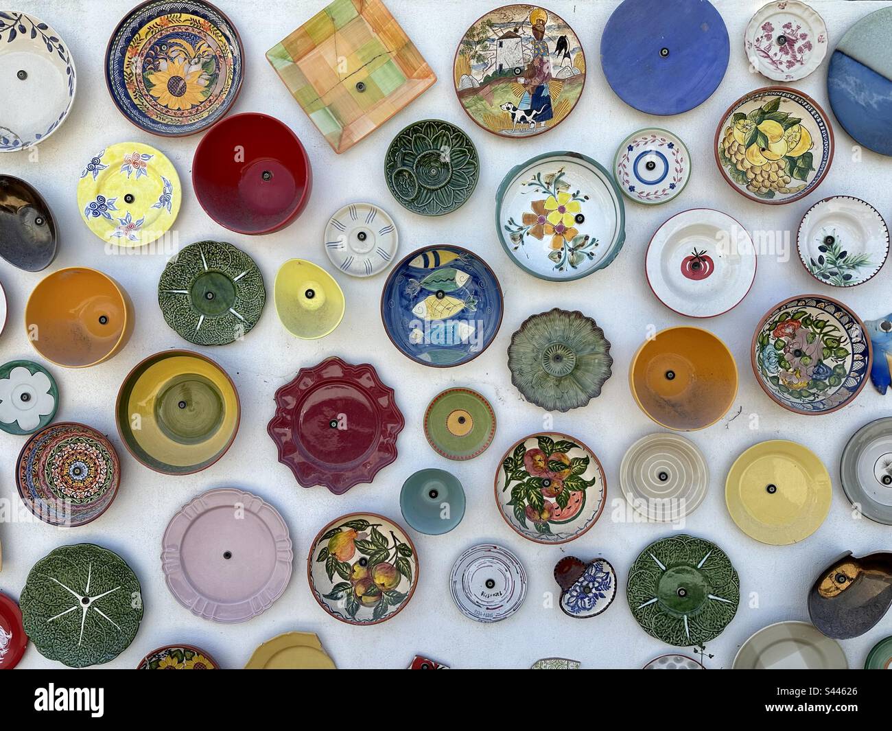Plates hanging on the outside wall of a pottery shop in the Algarve ...