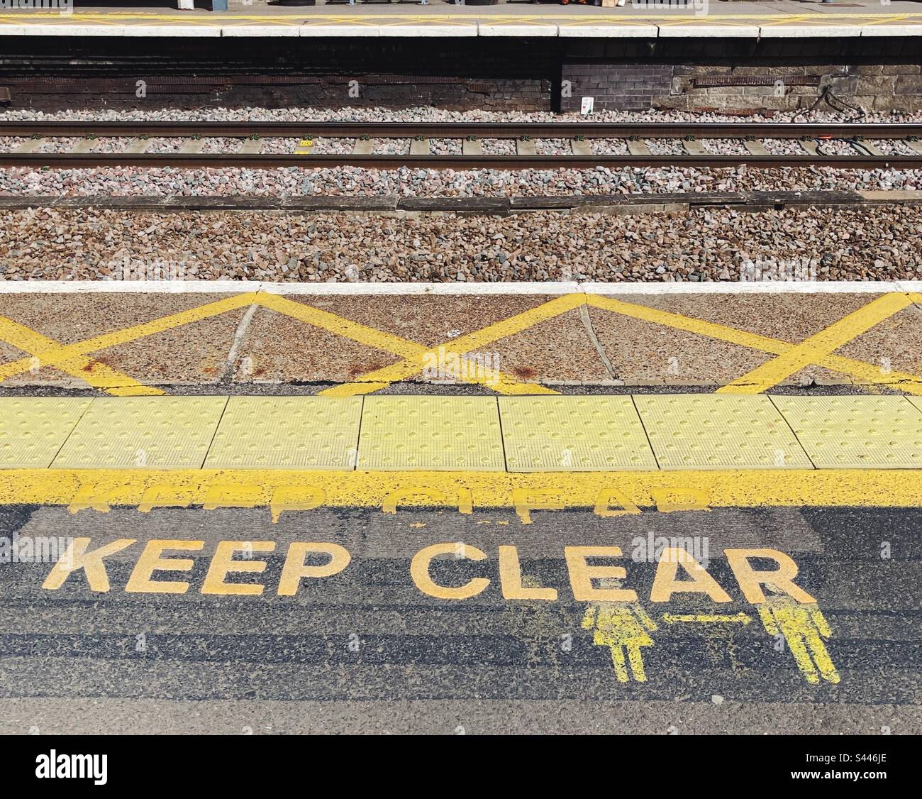 Keep clear sign on a train platform with a social distancing sign ...