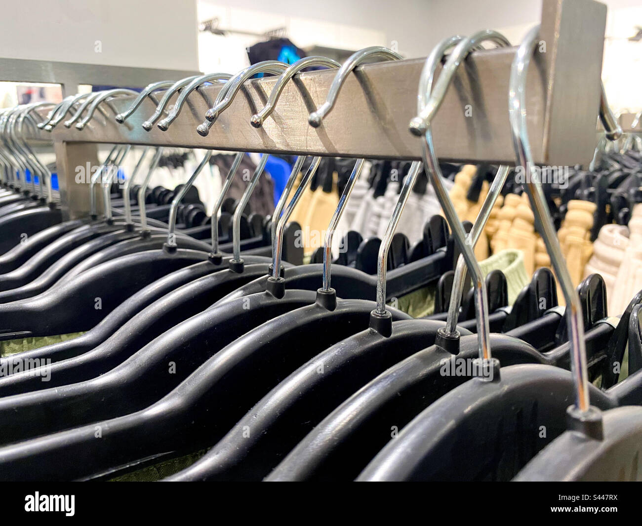 Clothes hangers on a display rail in a shop Stock Photo - Alamy