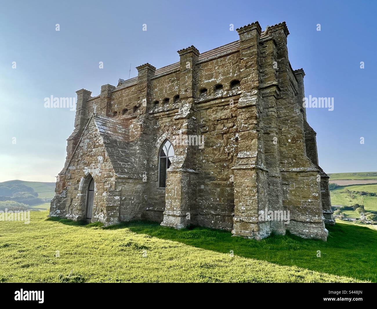 Side profile view of St Catherine’s chapel with bright blue sky and no ...