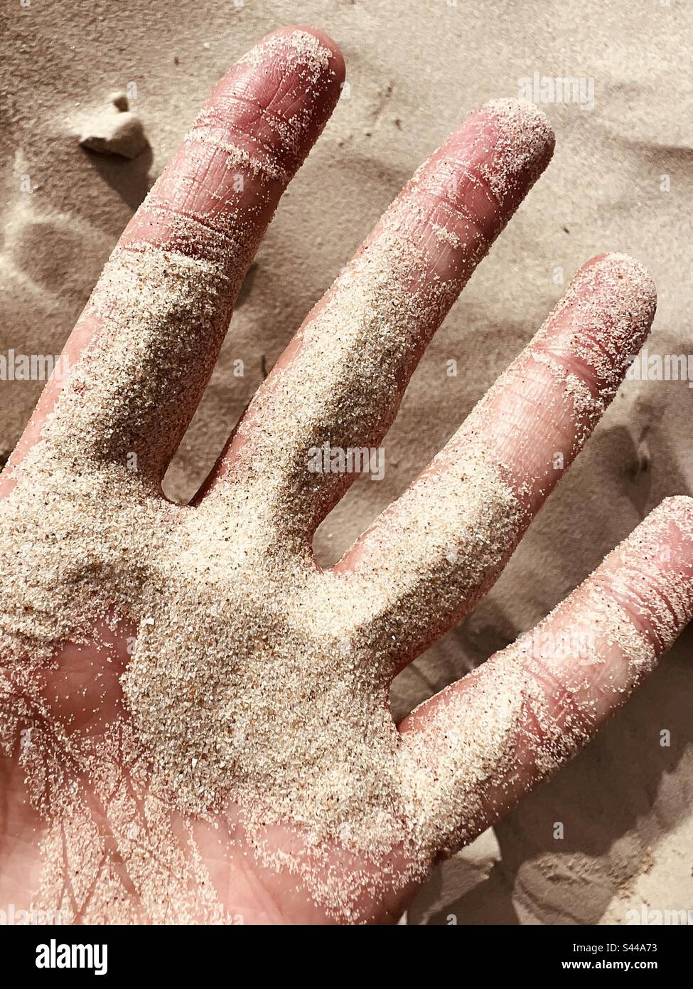Hand with sand Stock Photo - Alamy